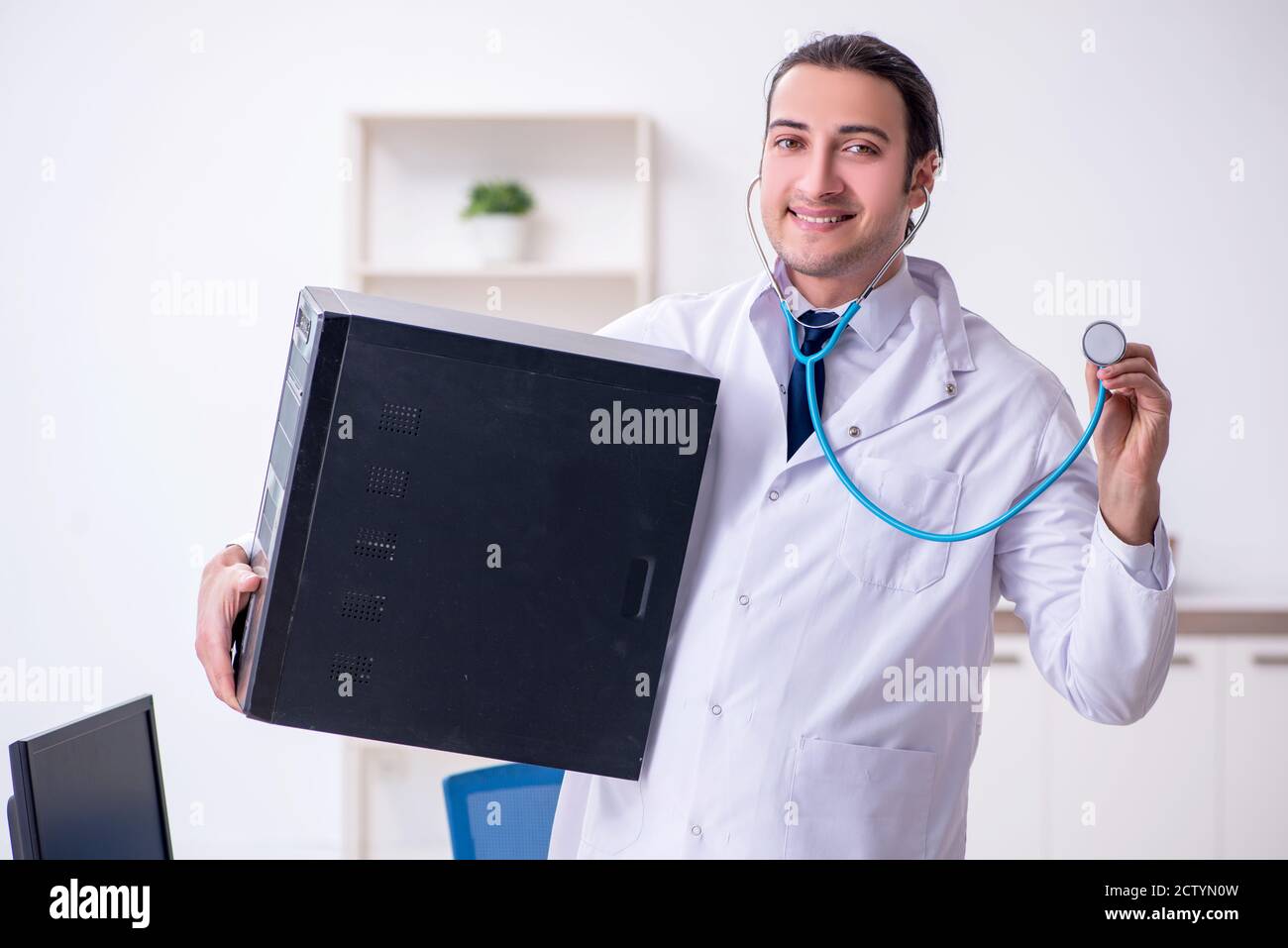 Young doctor with stethoscope repairing computer Stock Photo - Alamy