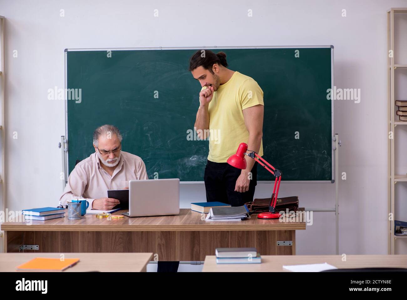 Old teacher and young student in the classroom Stock Photo - Alamy