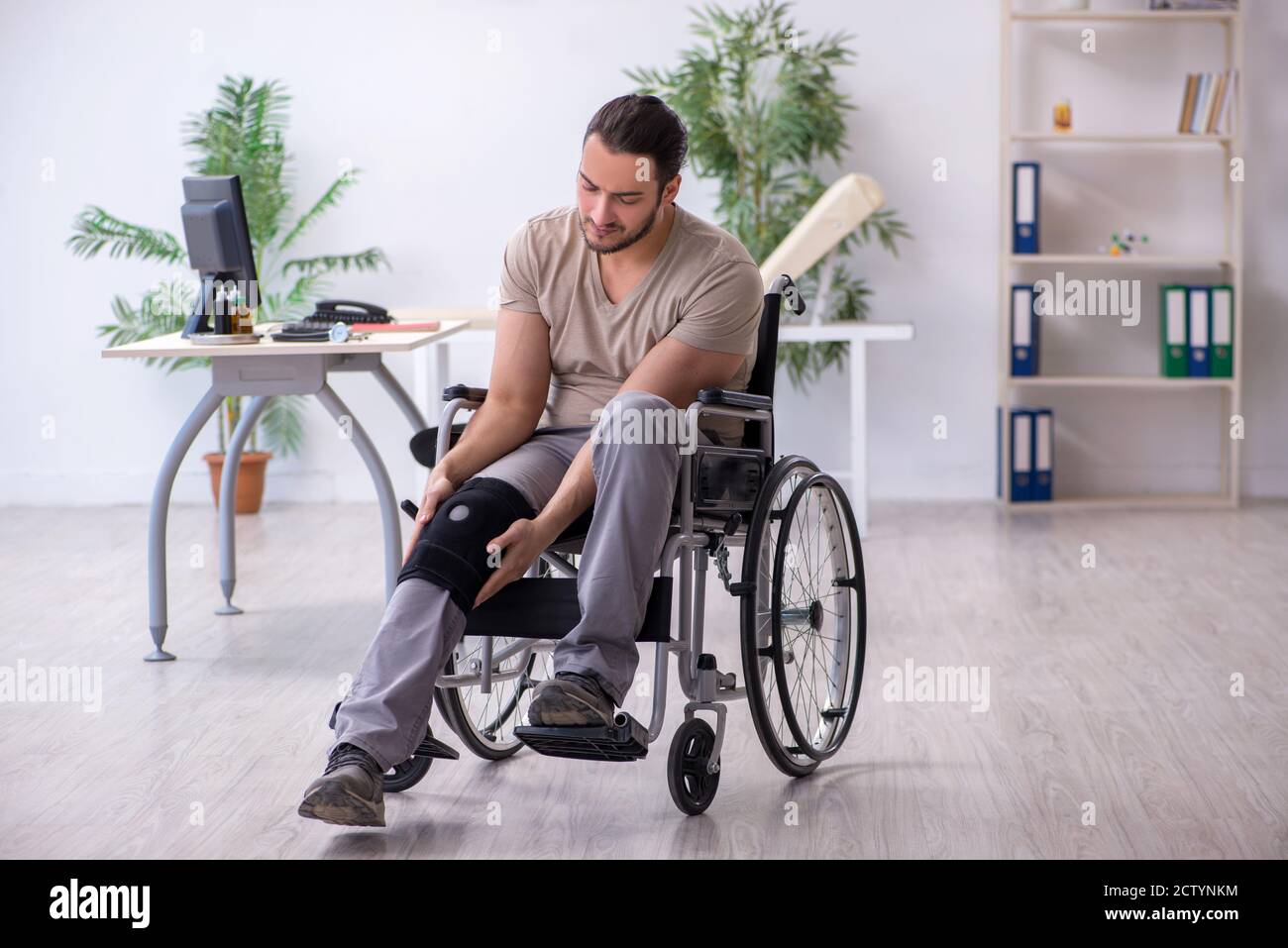 Young leg injured man in the wheel-chair Stock Photo - Alamy