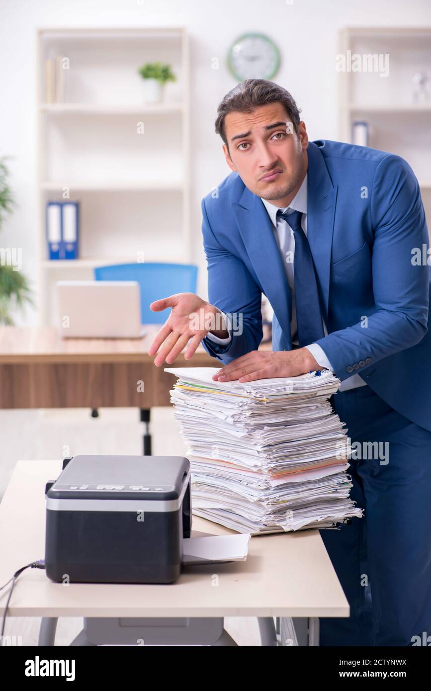 Young employee making copies at copying machine Stock Photo - Alamy