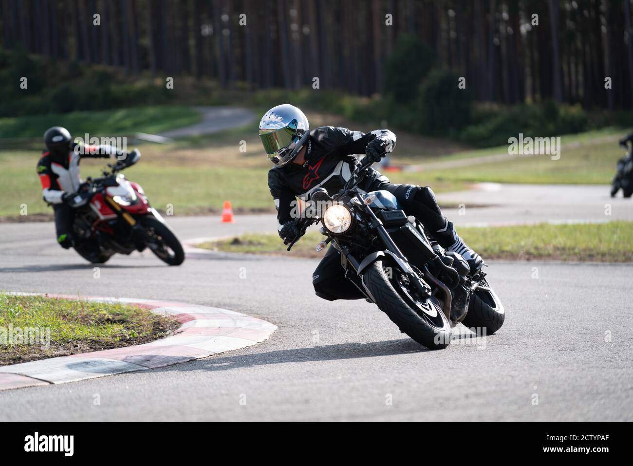 Motorcycle practice leaning into a fast corner on track Stock Photo - Alamy