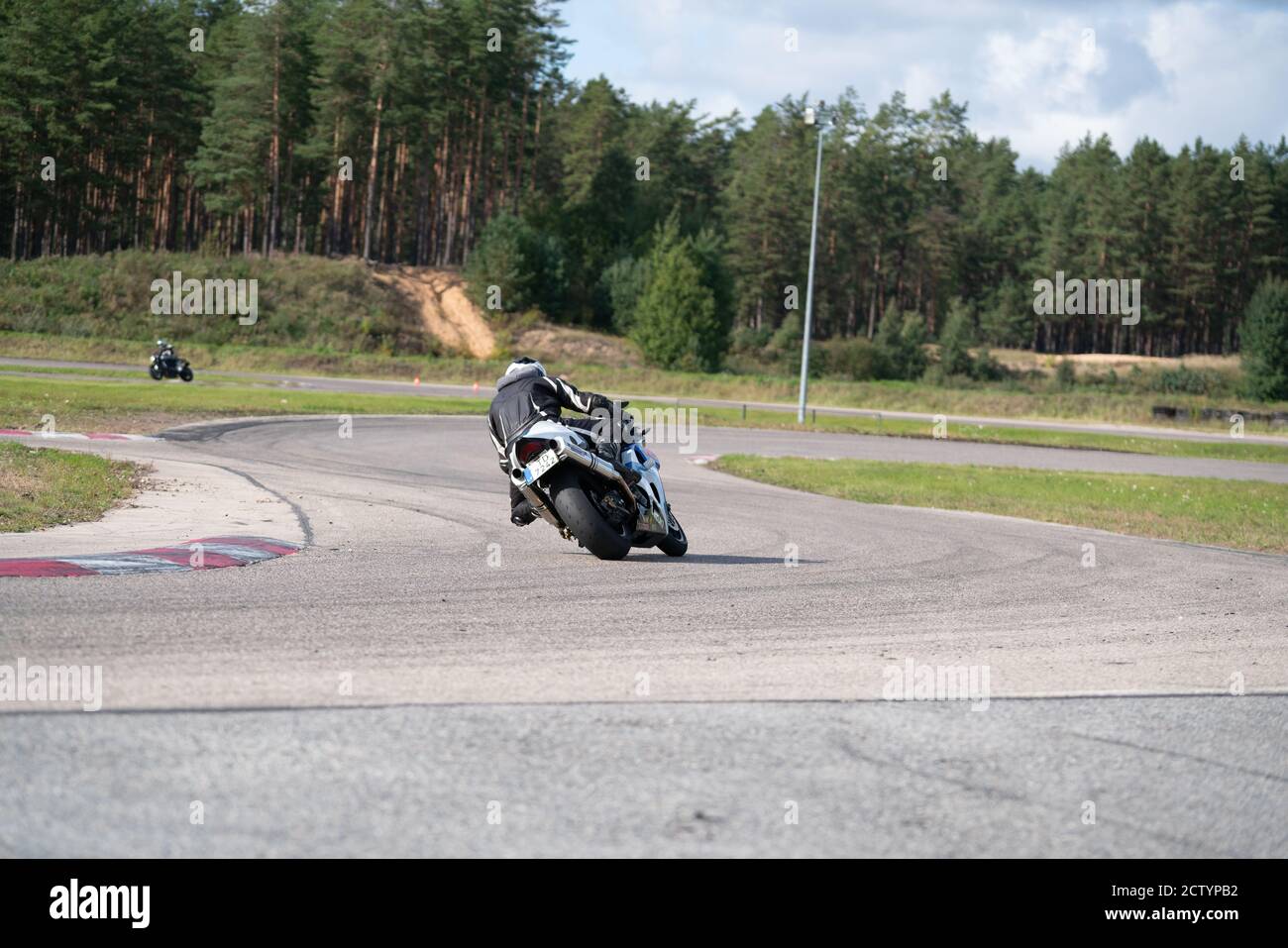 Motorcycle practice leaning into a fast corner on track Stock Photo - Alamy