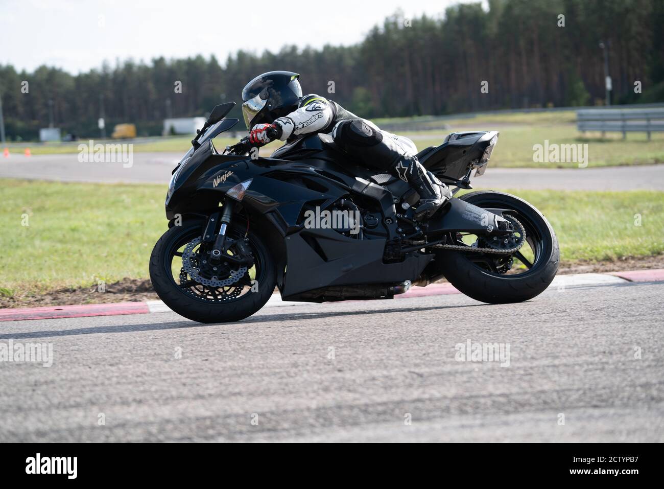 Motorcycle practice leaning into a fast corner on track Stock Photo - Alamy