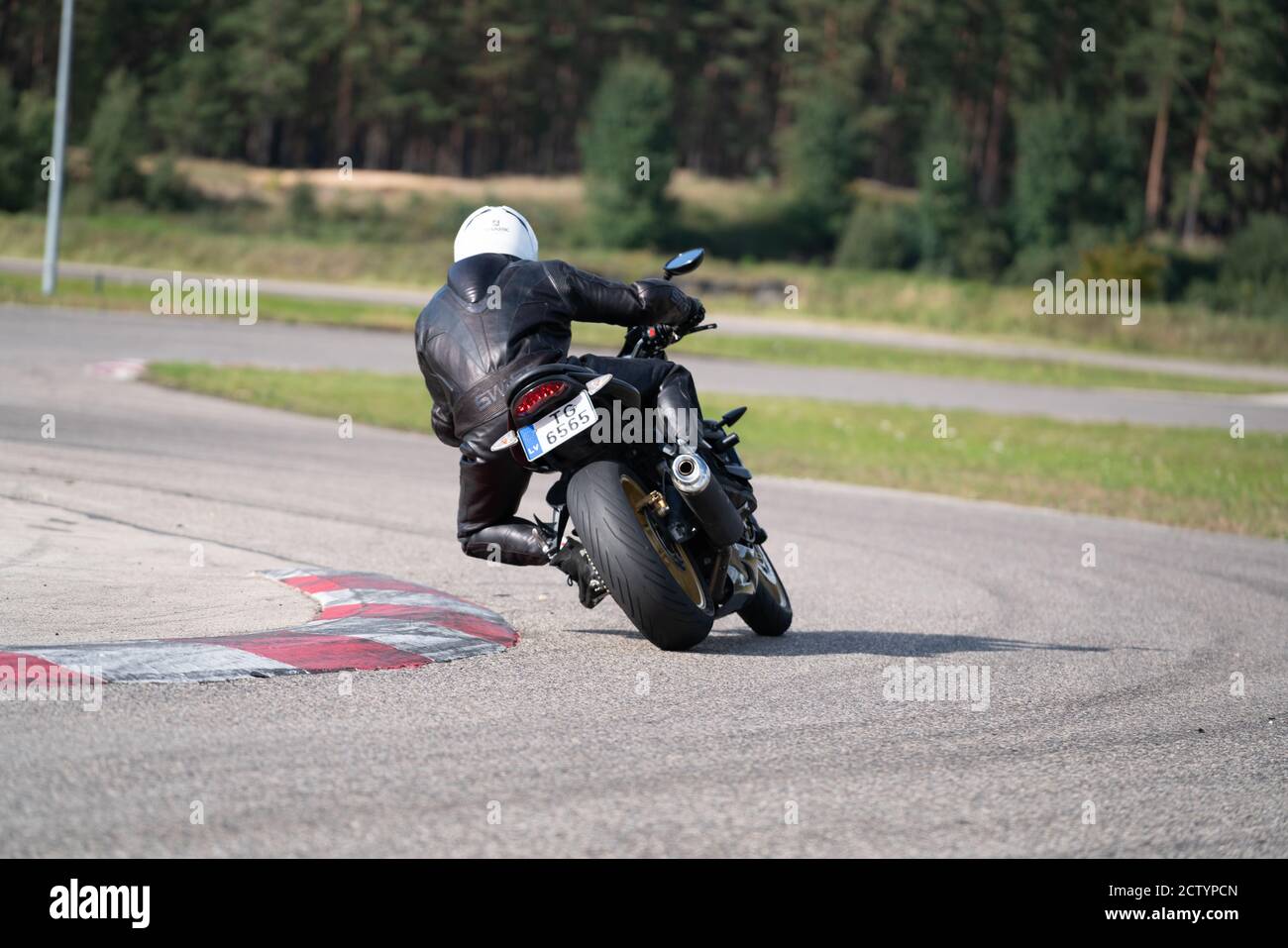 Motorcycle practice leaning into a fast corner on track Stock Photo - Alamy