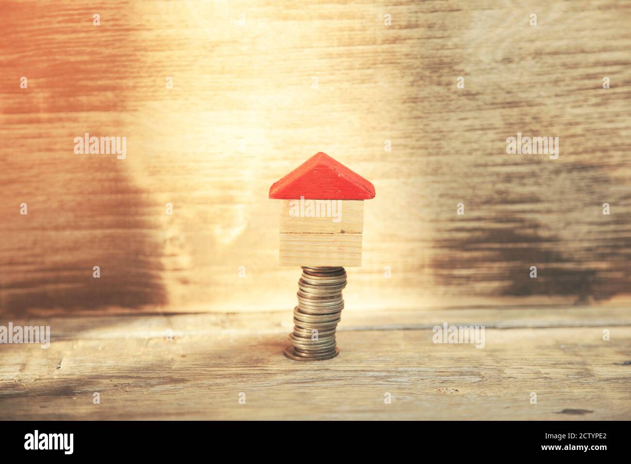 House with Coins on WoodenBackground Stock Photo - Alamy
