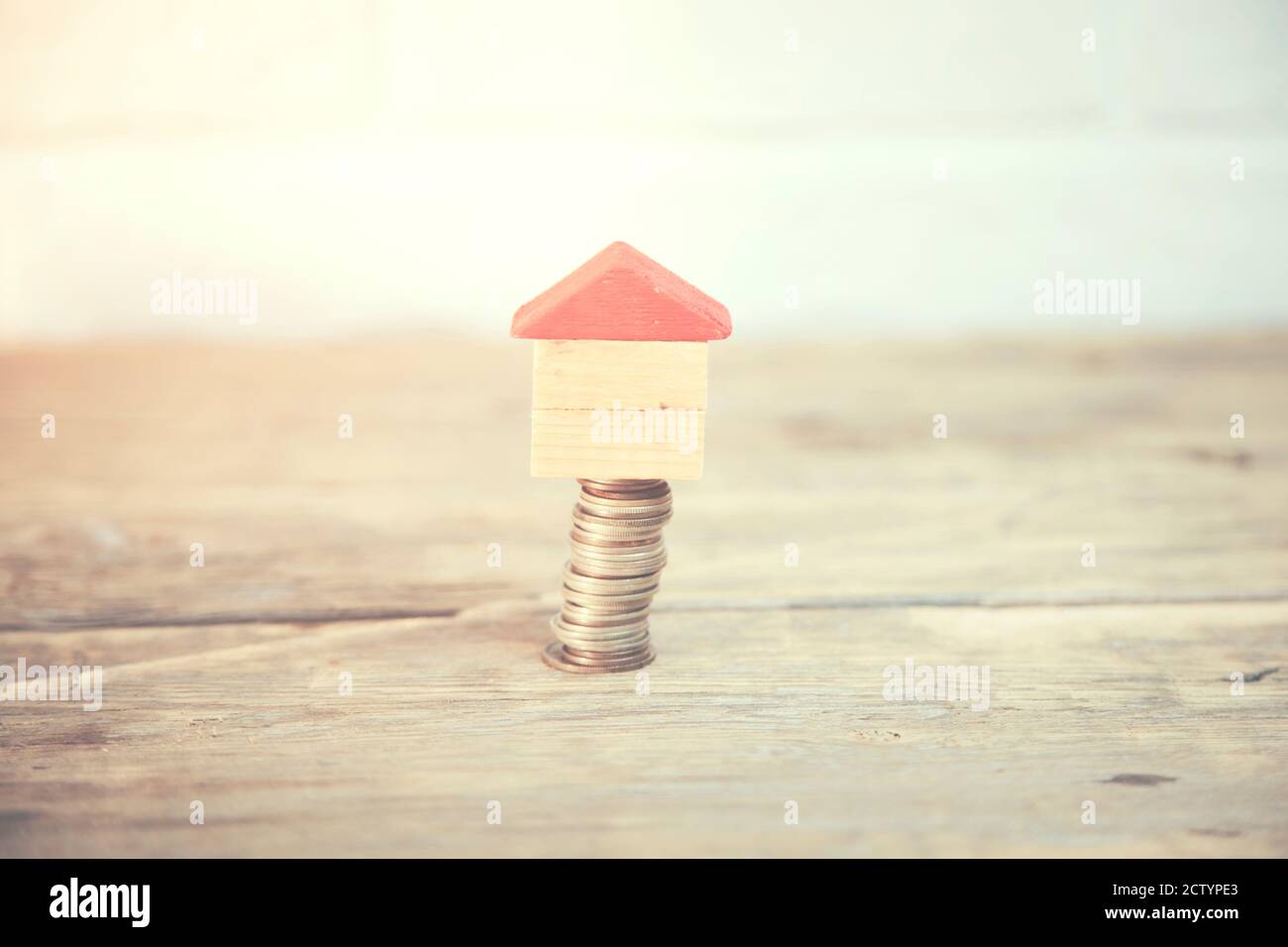 House with Coins on WoodenBackground Stock Photo - Alamy