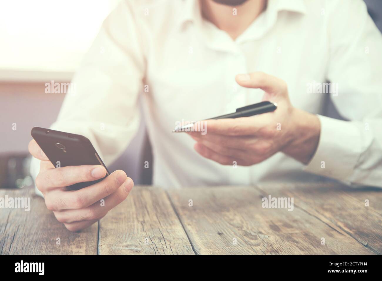 The man hand phone and pen Stock Photo - Alamy