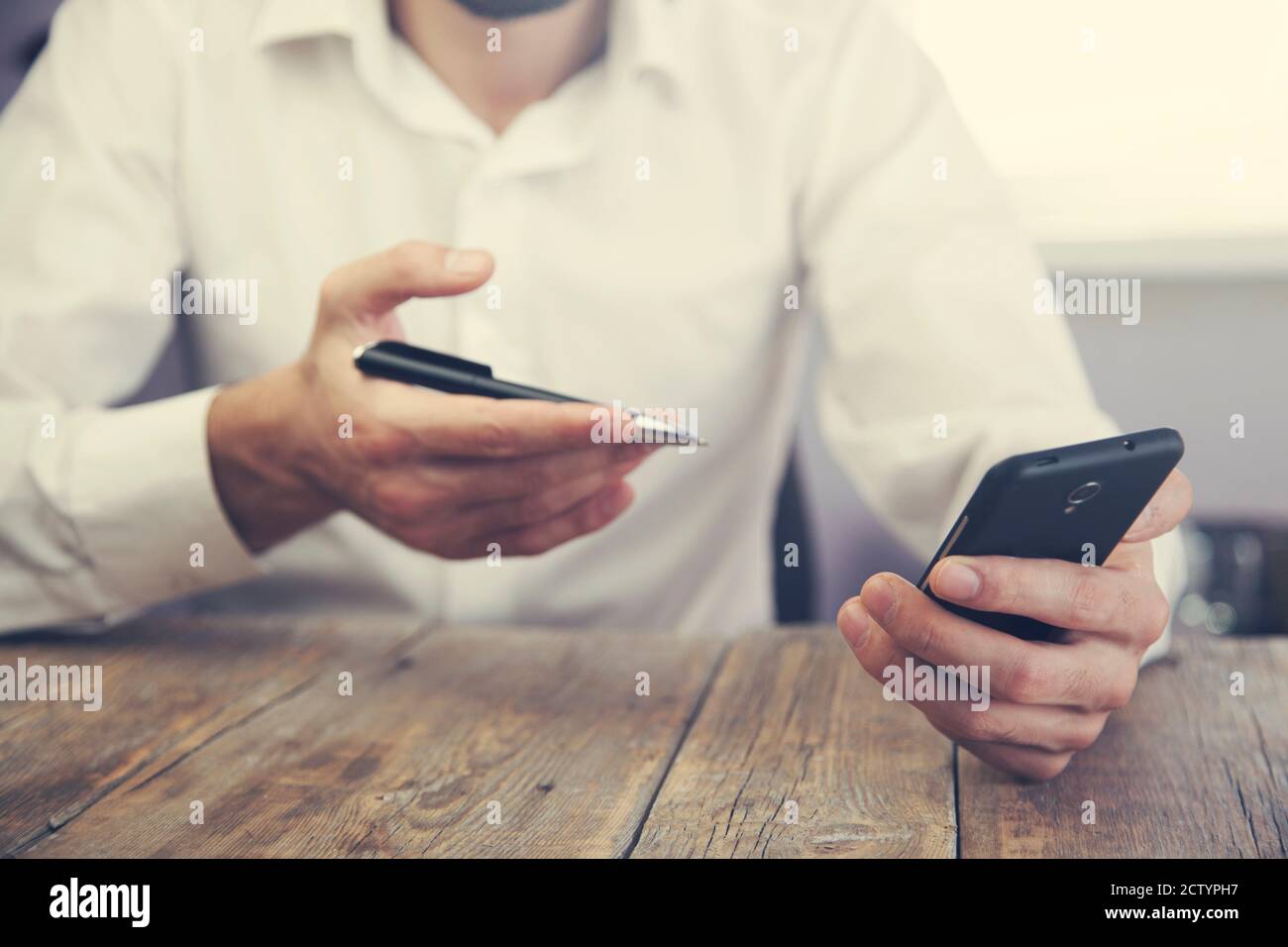 The man hand phone and pen Stock Photo - Alamy