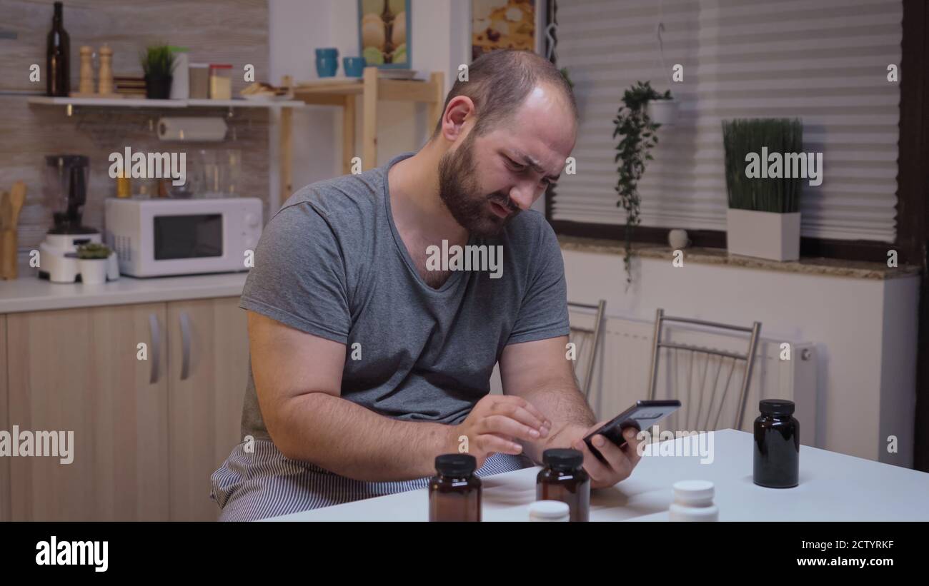 Stressed man with headache searching medicine information. Stressed ...