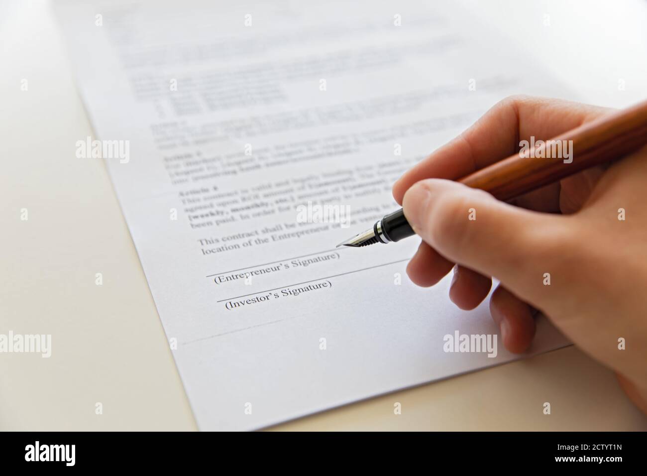 Signing the contract using a wooden fountain pen. Beautiful handwriting ...