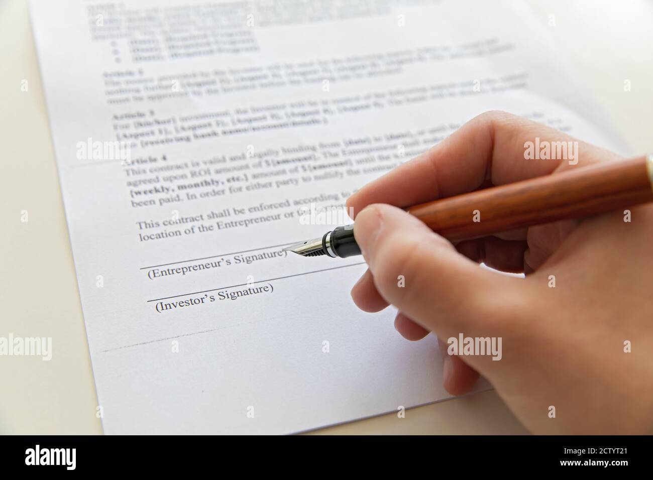 Signing the contract using a wooden fountain pen. Beautiful handwriting ...