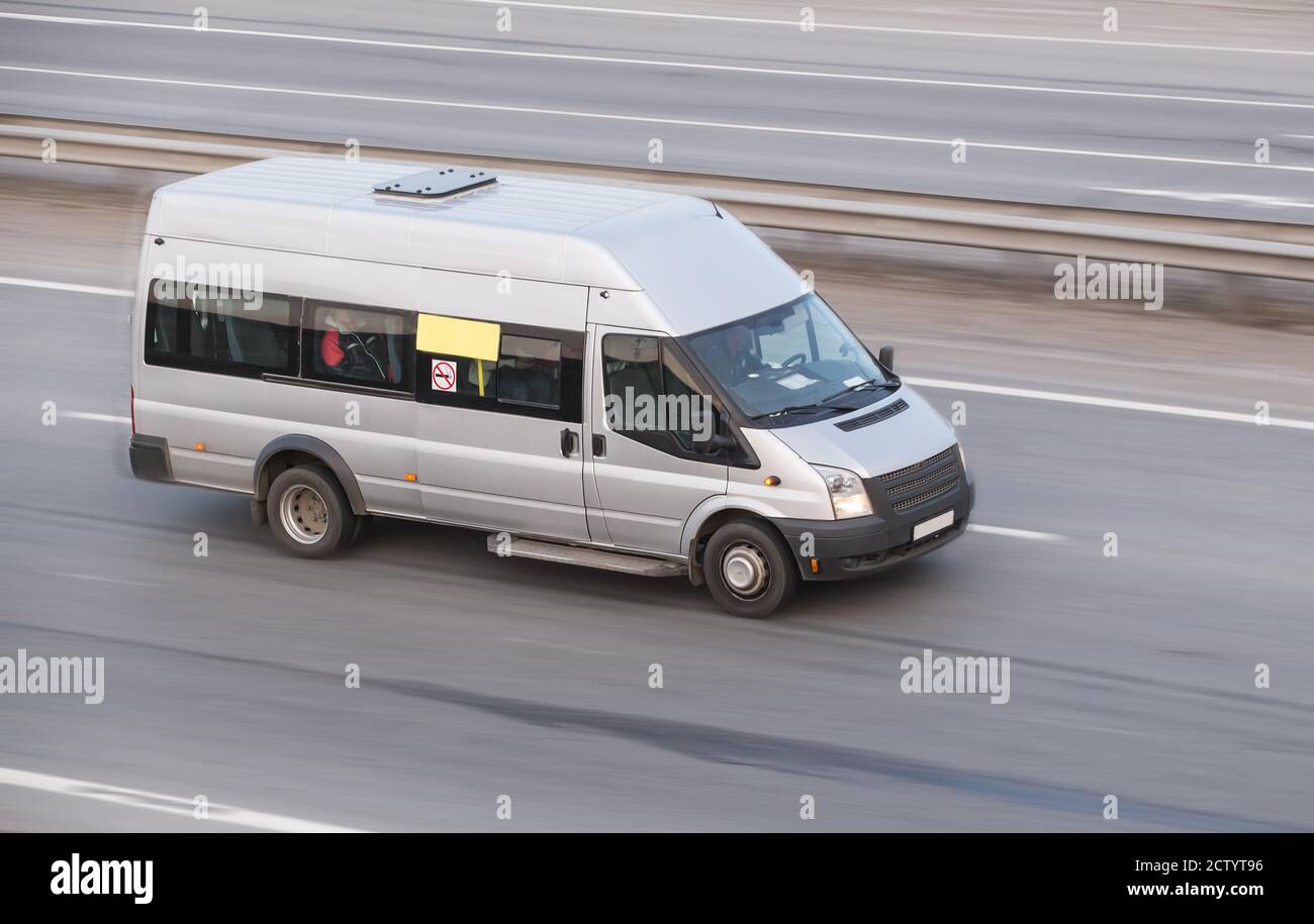 small white bus goes on highway in evening Stock Photo - Alamy