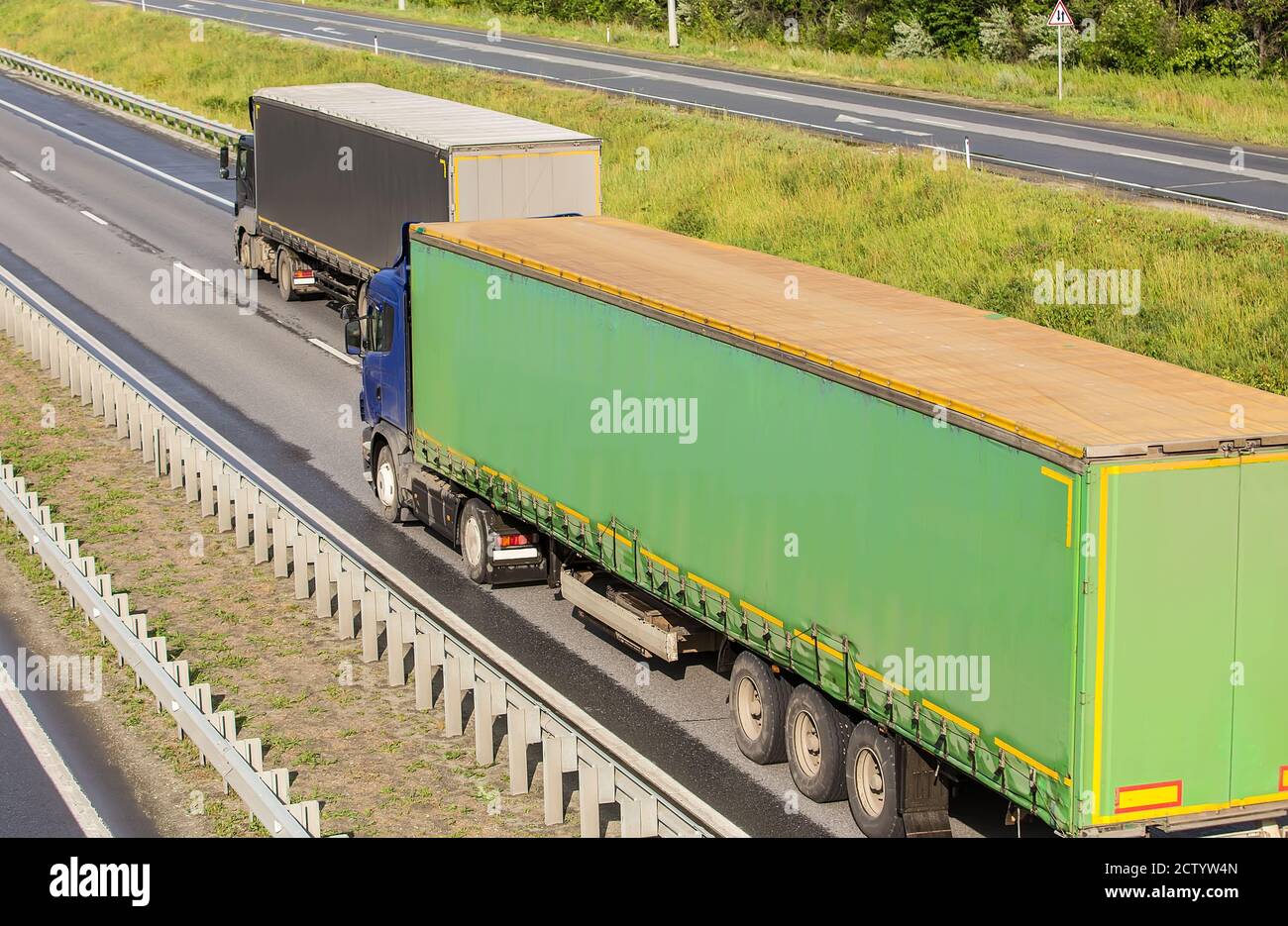 Two trucks carry cargo along the highway Stock Photo - Alamy