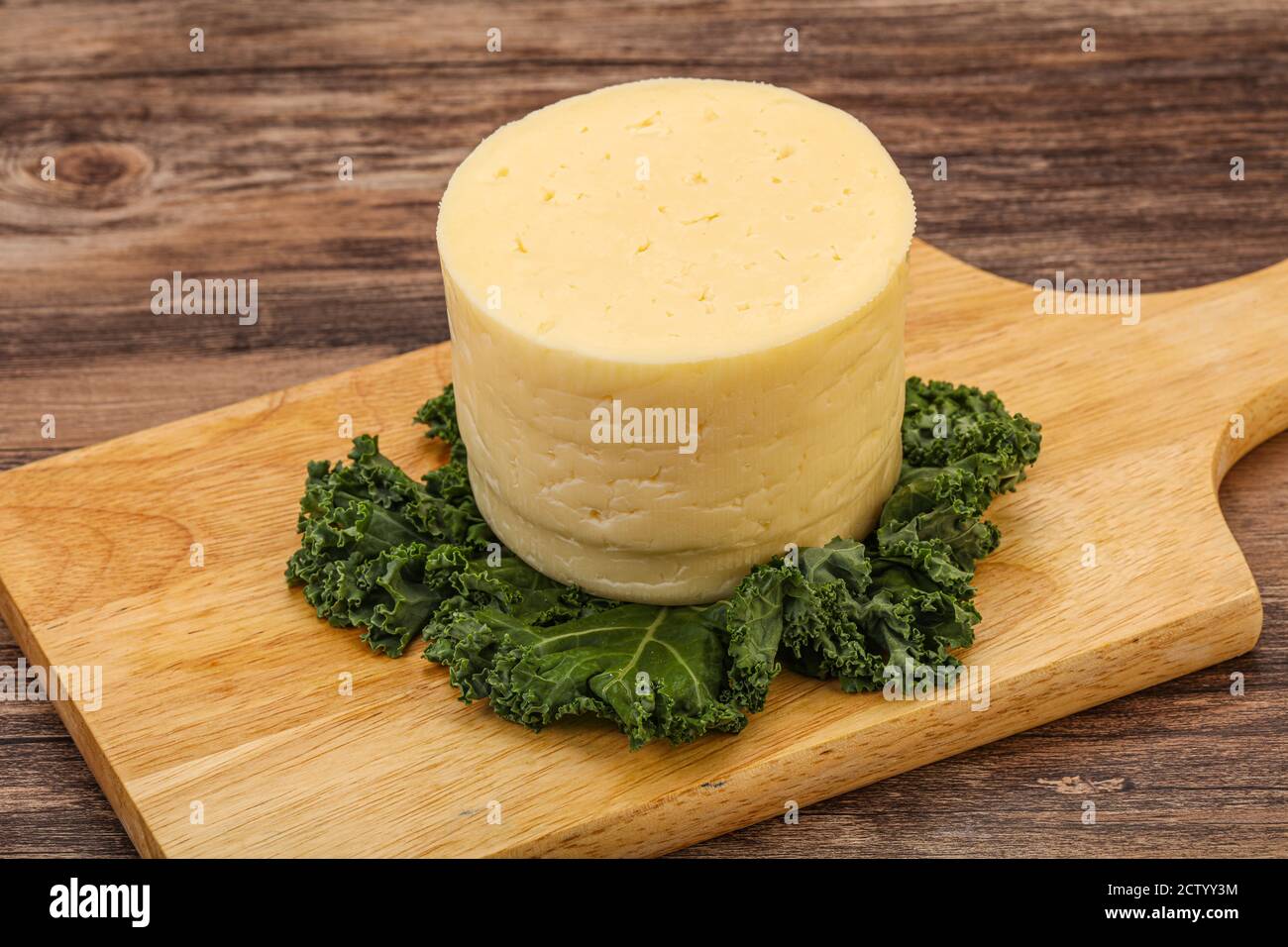 Yellow round dairy soft cheese piece Stock Photo - Alamy