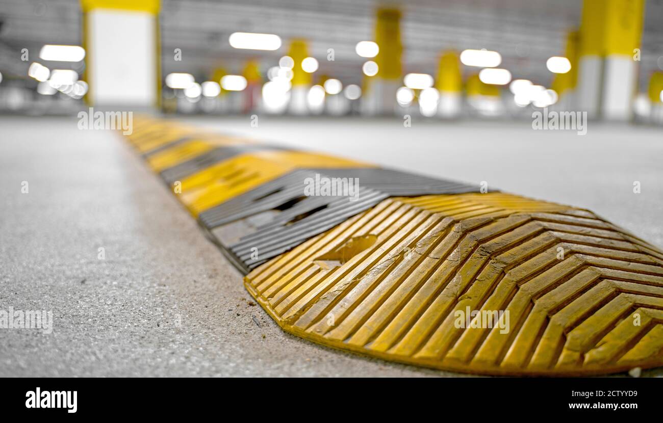 Traffic safety speed bump on an asphalt road in a parking area. Speed ...