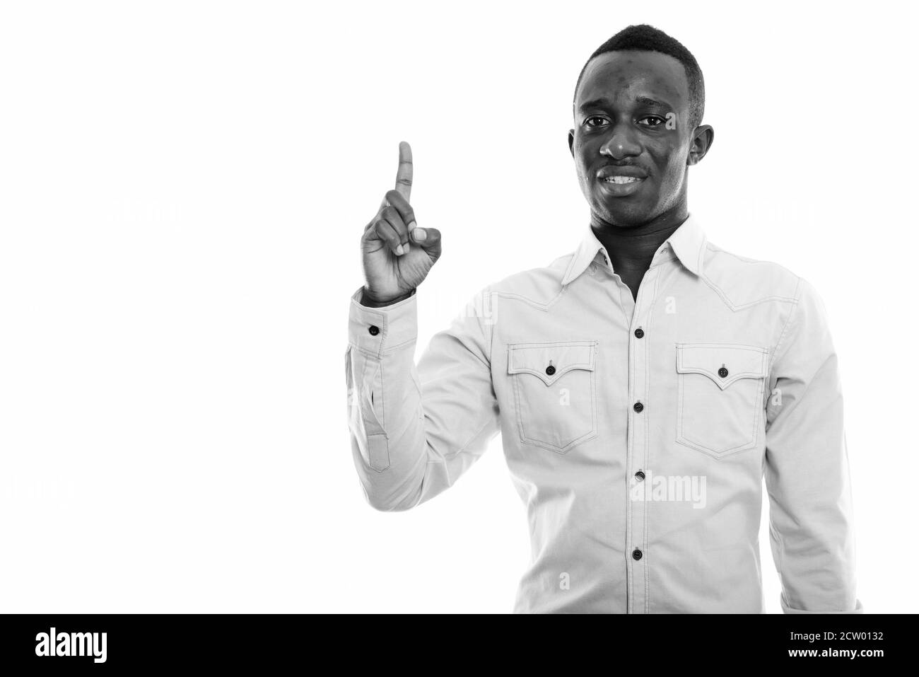 Studio shot of young happy black African man smiling while pointing ...