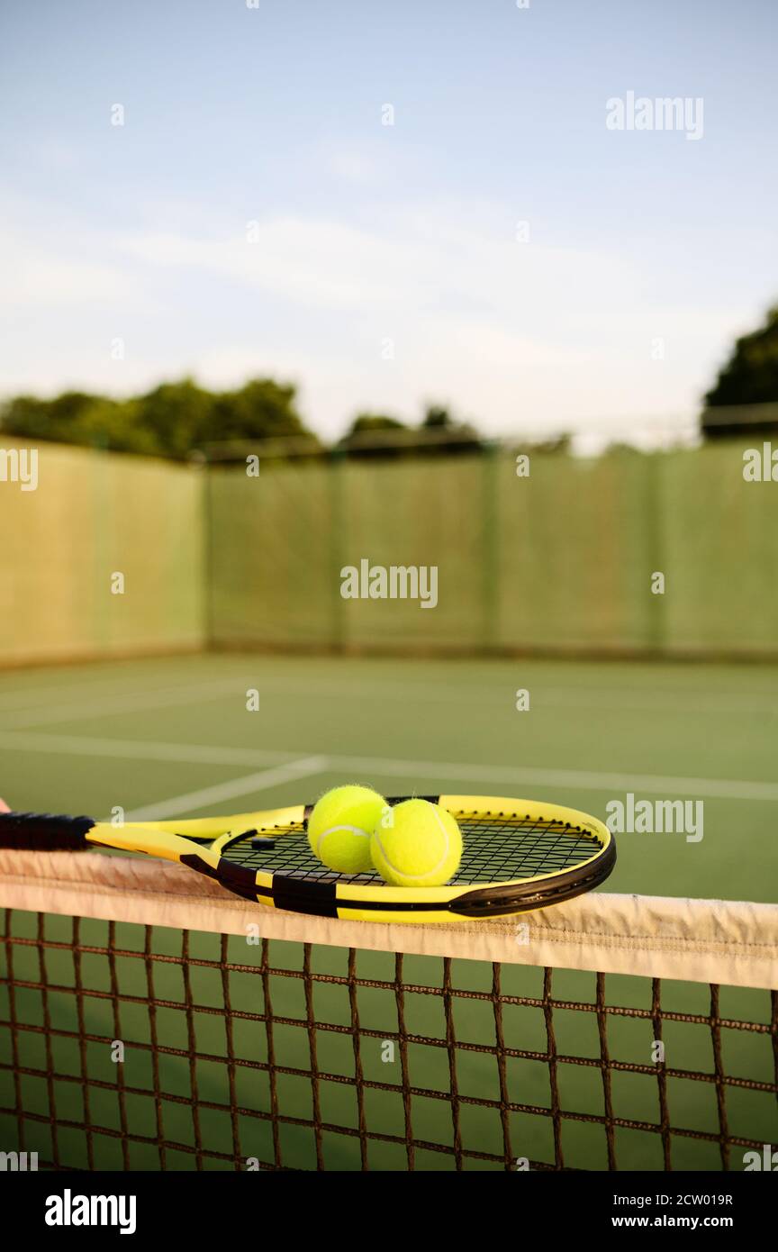 Tennis racket and balls on the net, outdoor court Stock Photo - Alamy