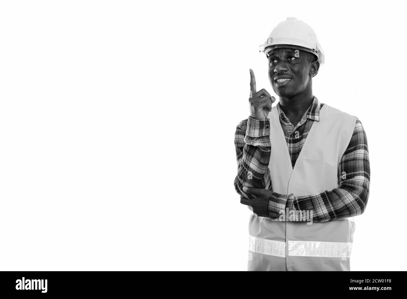 Happy young African man construction worker smiling and thinking while ...