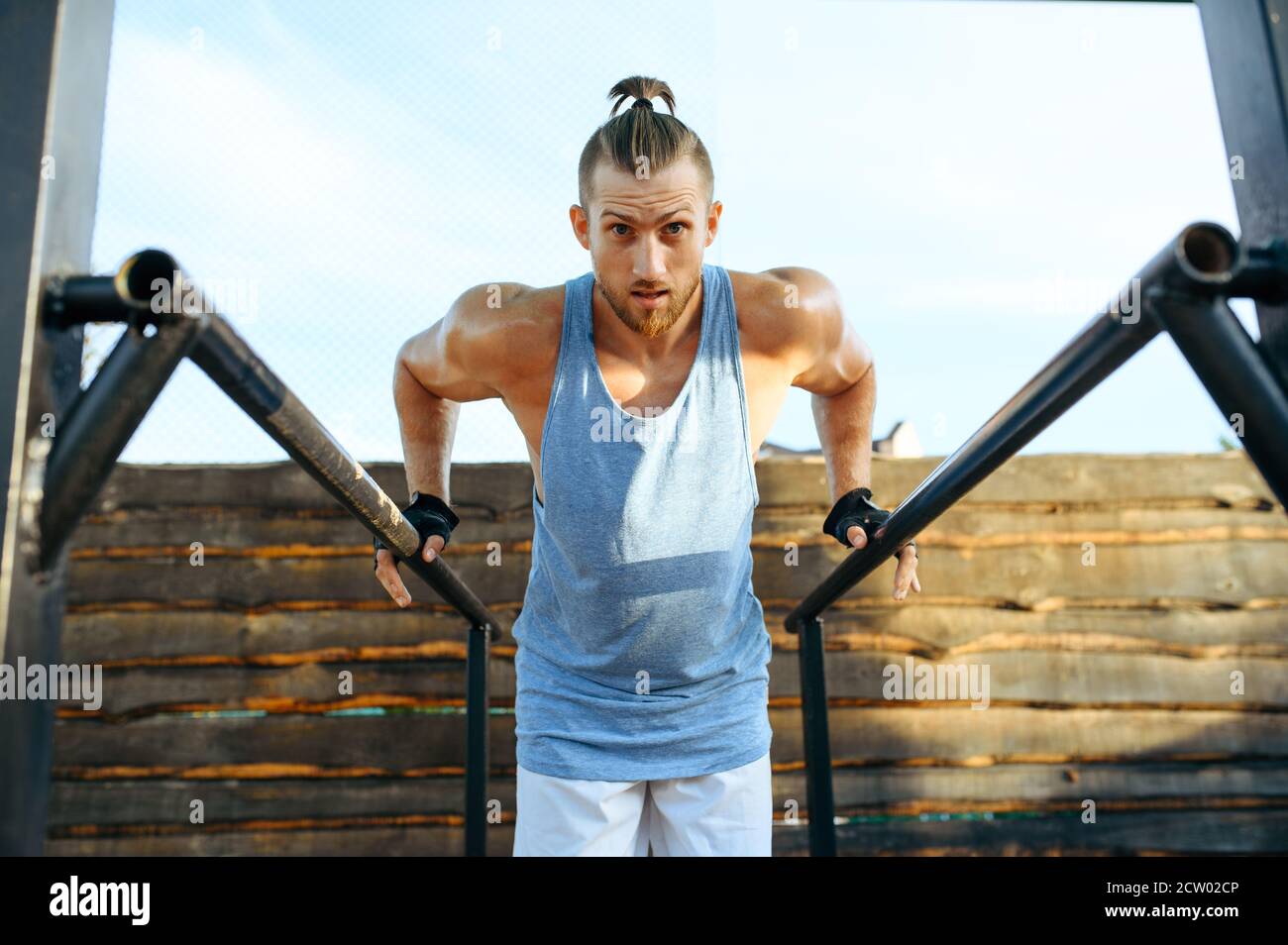 Man doing exercise on bars, street workout Stock Photo - Alamy
