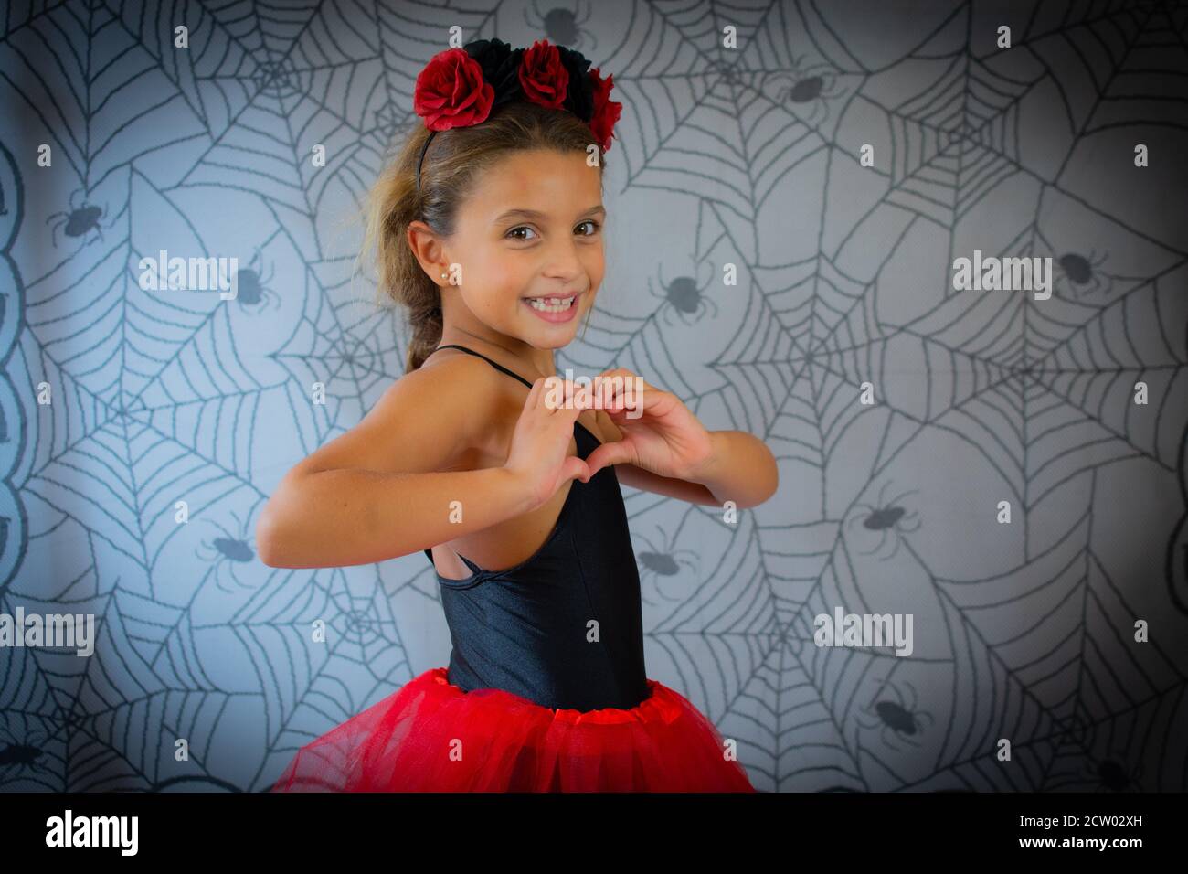 funny child girl in witch costume for Halloween over cobweb background ...