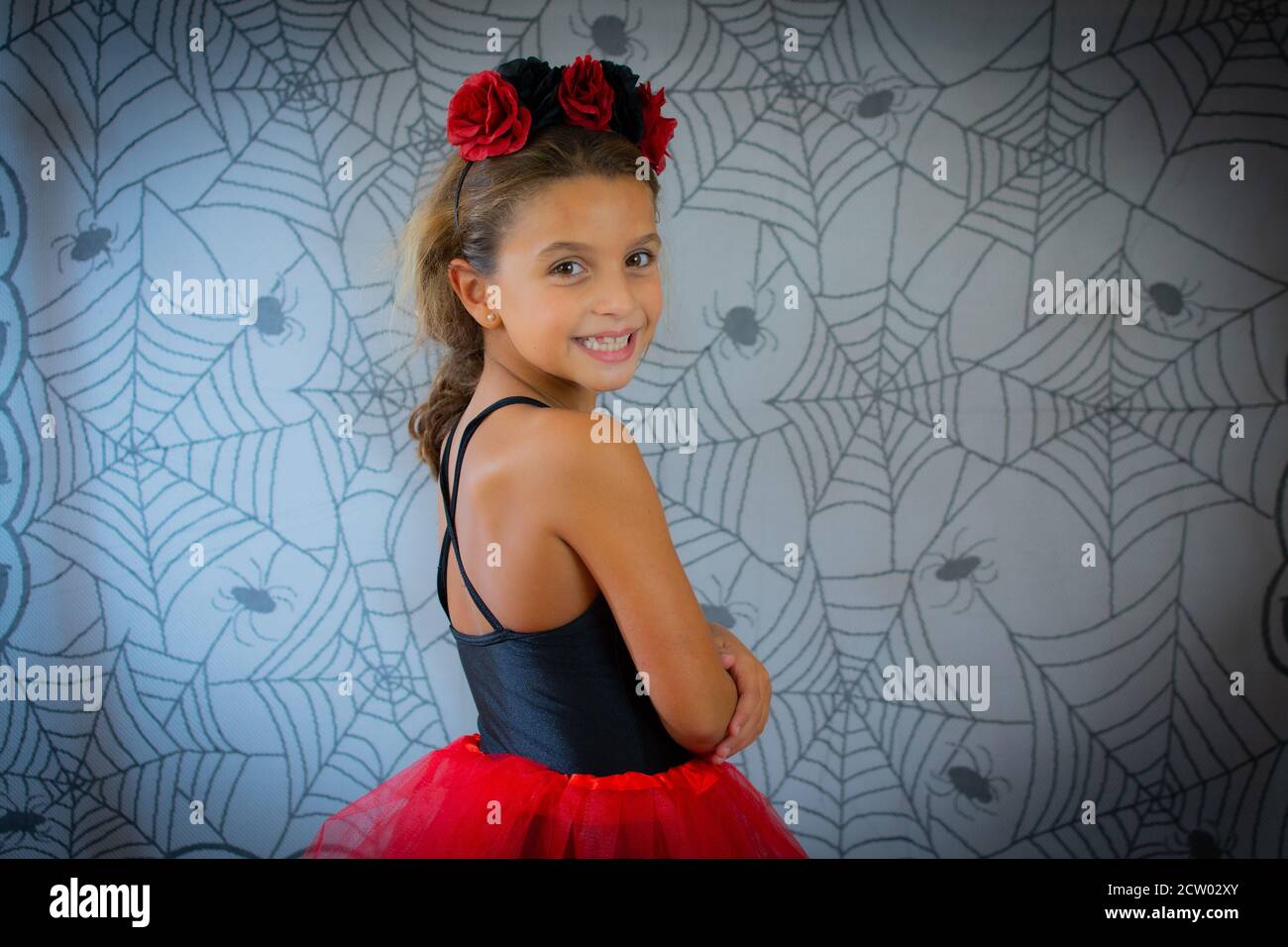 funny child girl in witch costume for Halloween over cobweb background ...