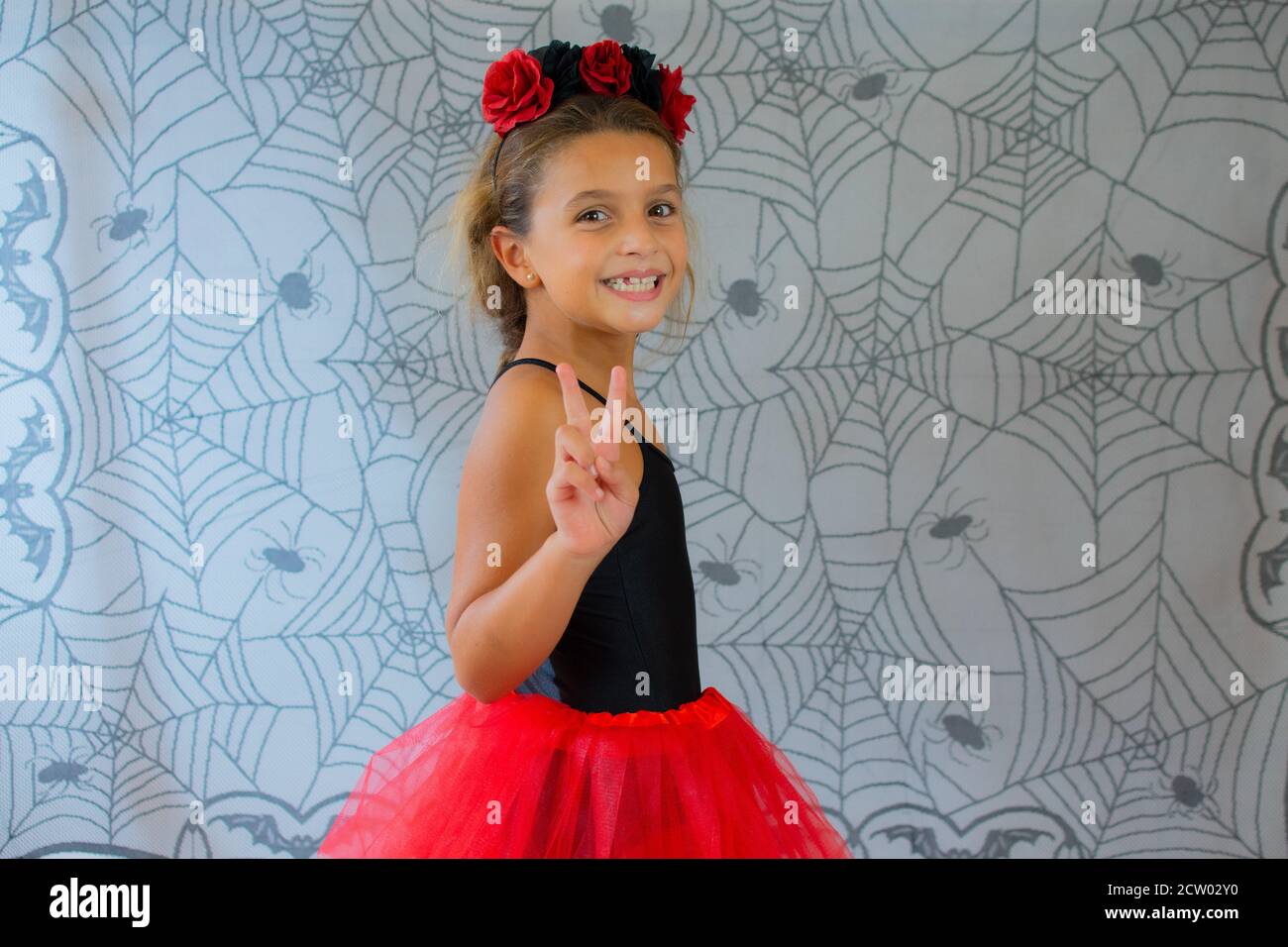 funny child girl in witch costume for Halloween over cobweb background ...