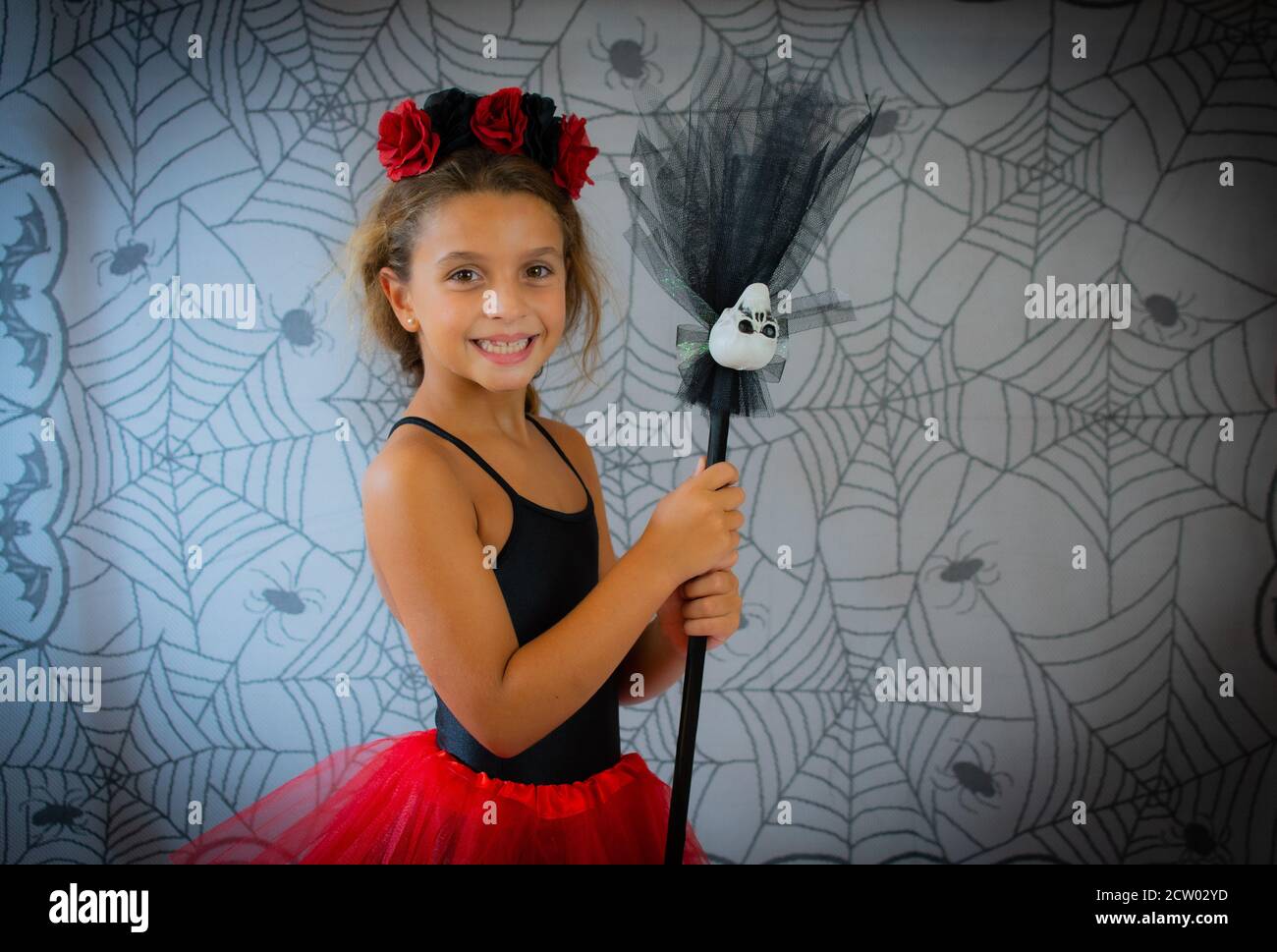 funny child girl in witch costume for Halloween over cobweb background ...