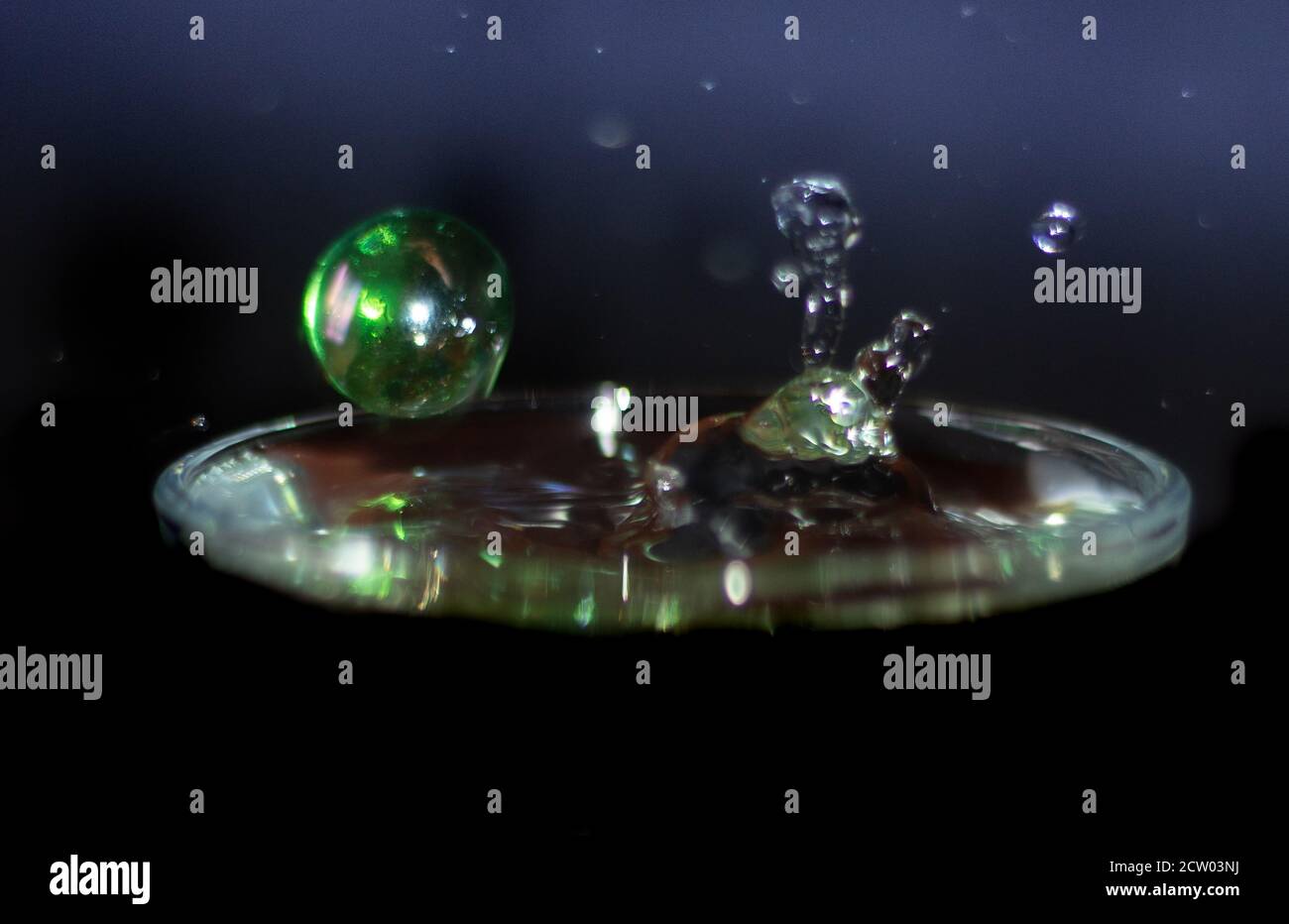 Colored crystal ball colliding in the water and water bubbles bouncing ...