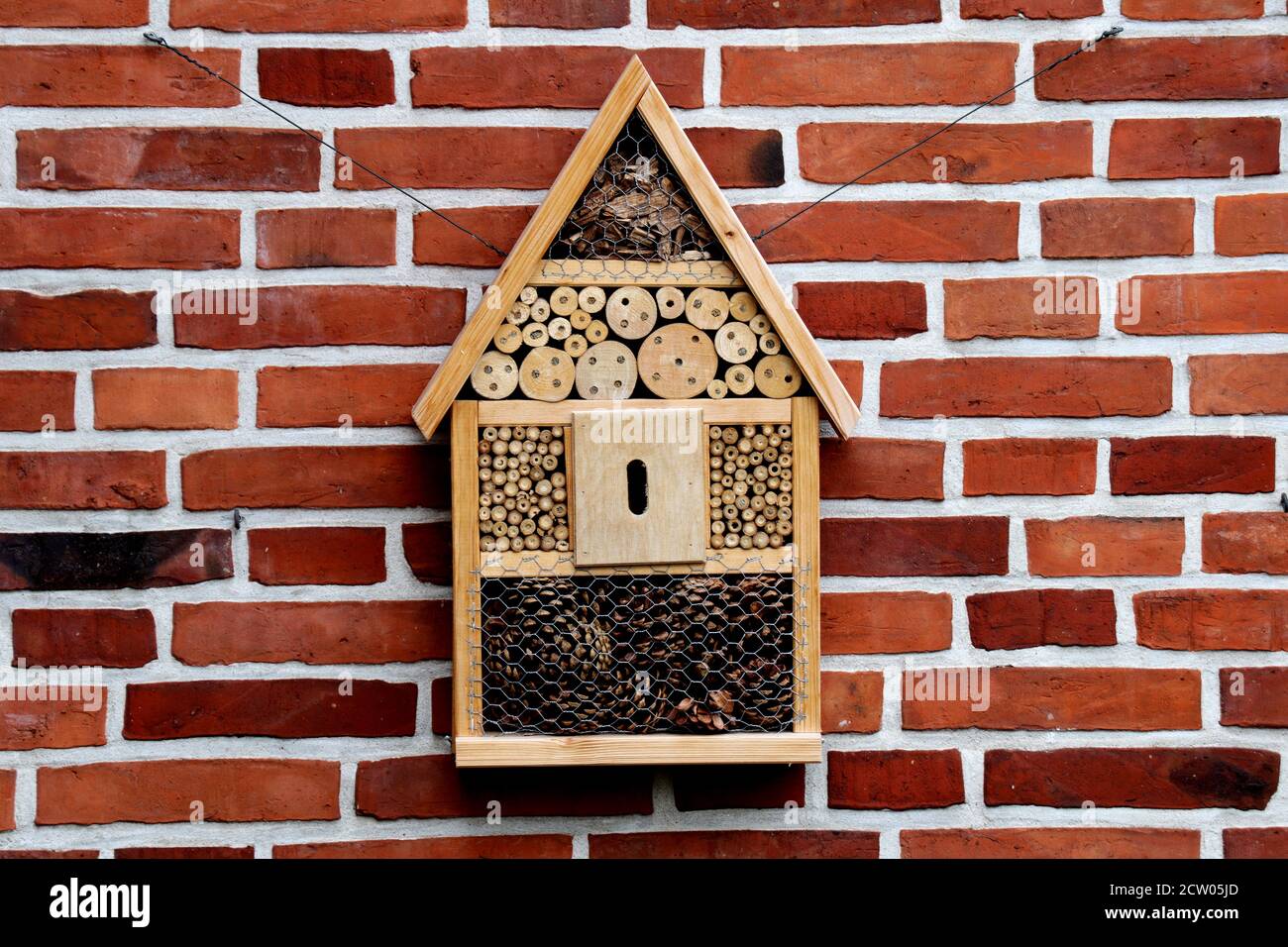 Wooden Bee House hanging on a brick wall - rural scene Stock Photo - Alamy