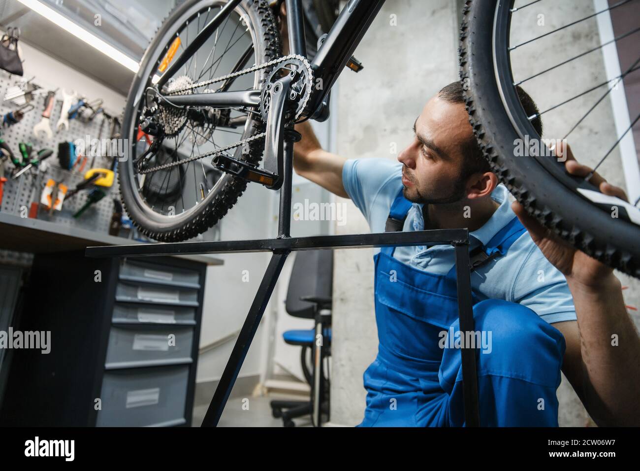 Bicycle repair, man checks the wheel for backlash Stock Photo - Alamy