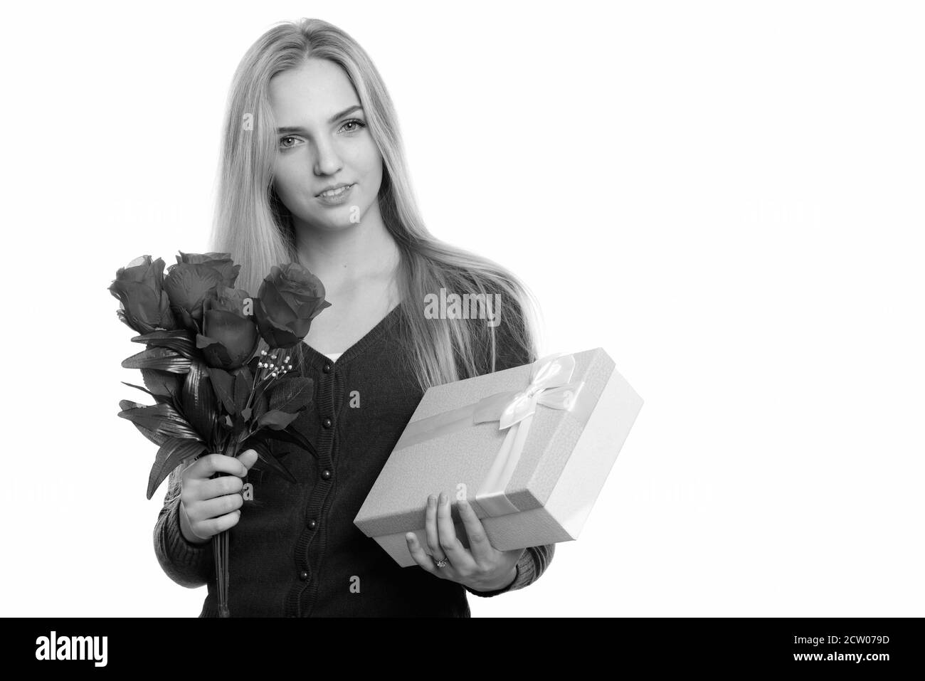 Studio shot of young beautiful teenage girl holding roses and gift box ...