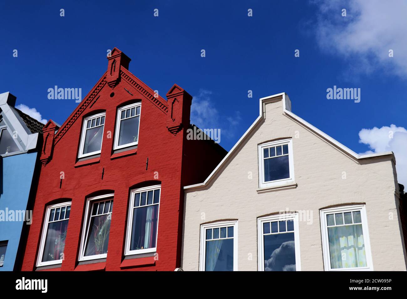 Three color houses in a row - blue , red and white Stock Photo - Alamy