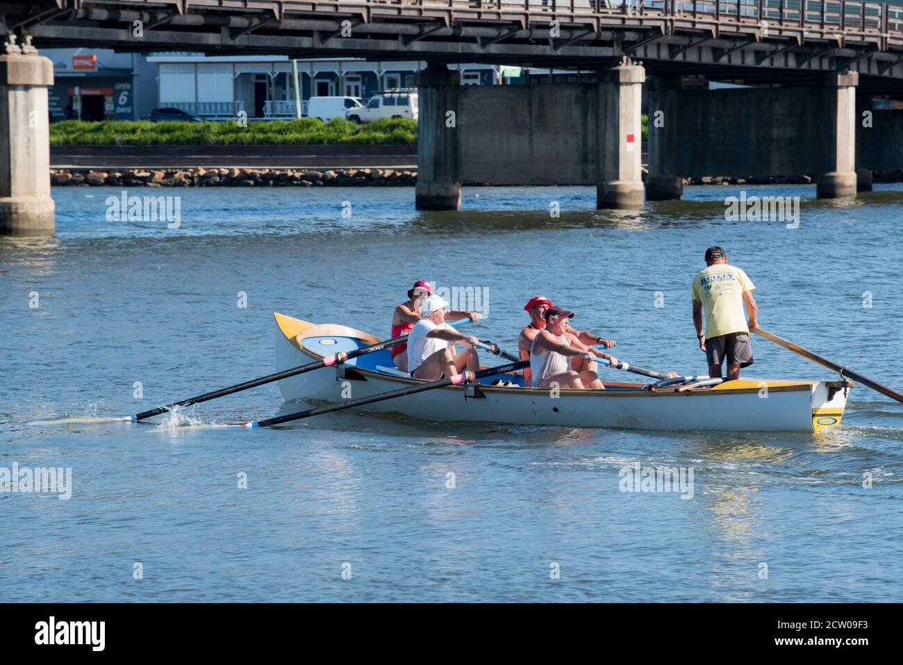 A group of older men practice rowing in a long Australian surf rescue ...