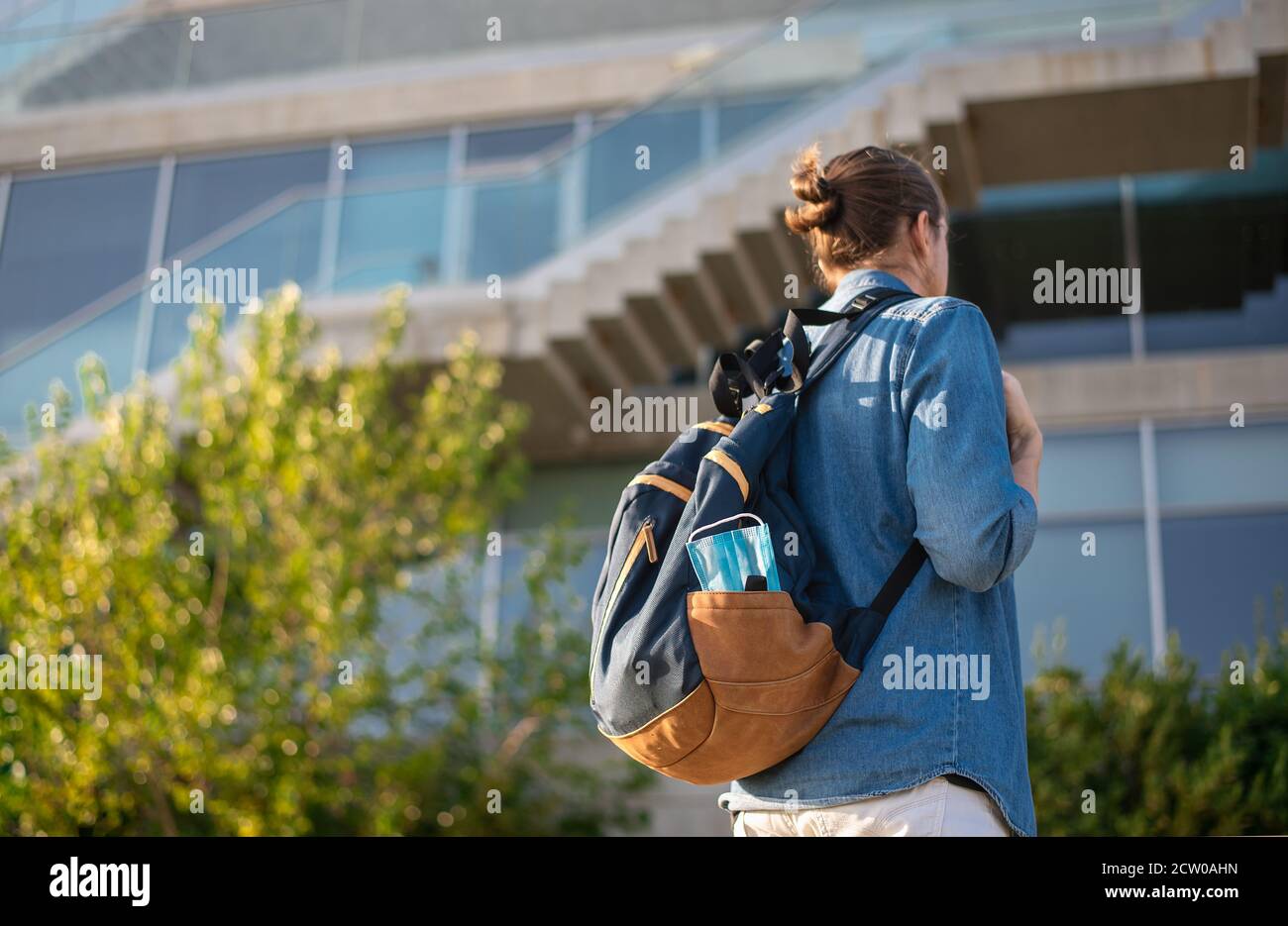 Student holding backpack and face mask outdoors Stock Photo - Alamy