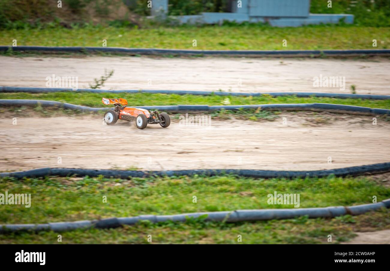 Orange RC buggy going quickly throuh a turn on an outdoor track Stock ...