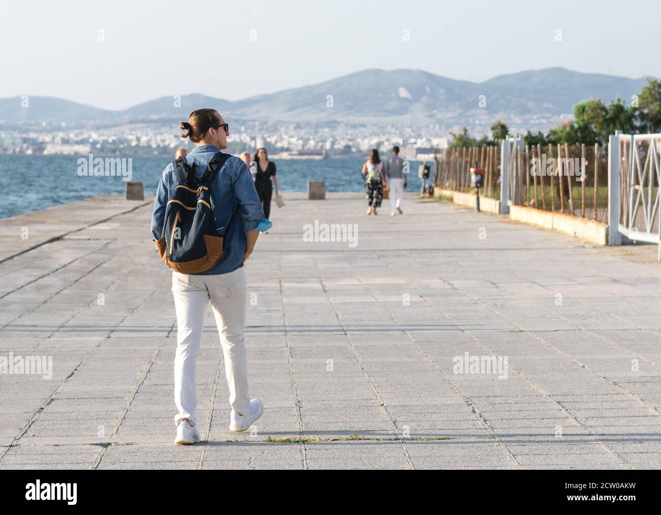 Guy long hair backpack walking hi-res stock photography and images - Alamy