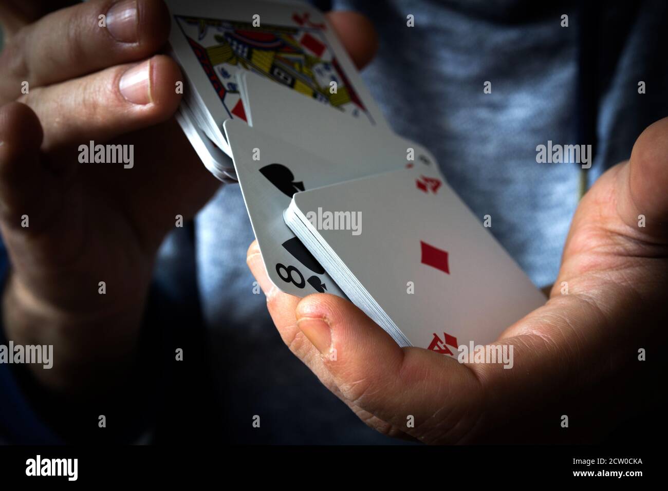 A deck of playing cards in hand, shuffling the deck, gambling Stock ...