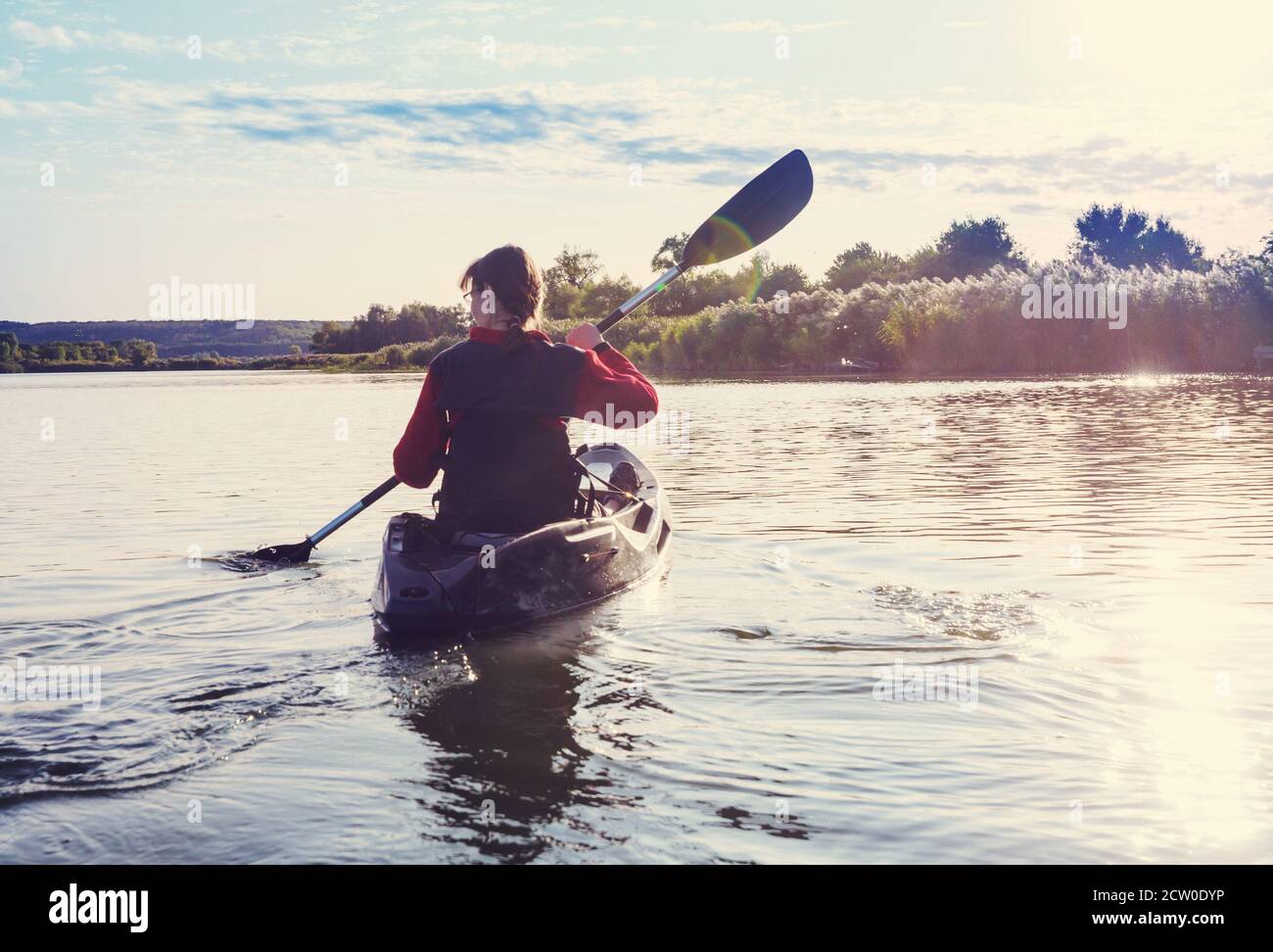 Rear view of kayaker paddle kayak in summer river Stock Photo - Alamy