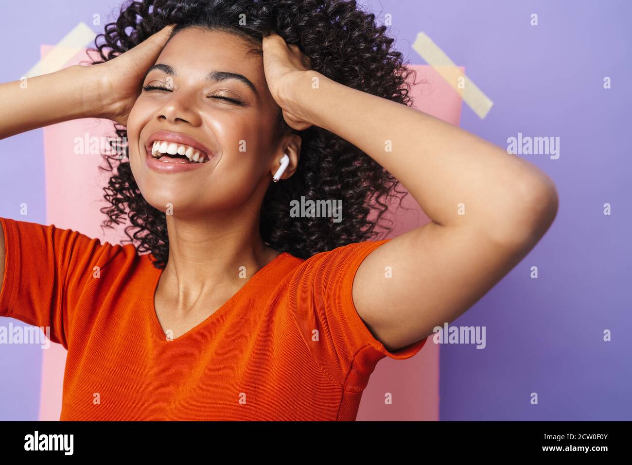 Image Of Pleased African American Woman Grabbing Her Head And Using Earphones Isolated Over