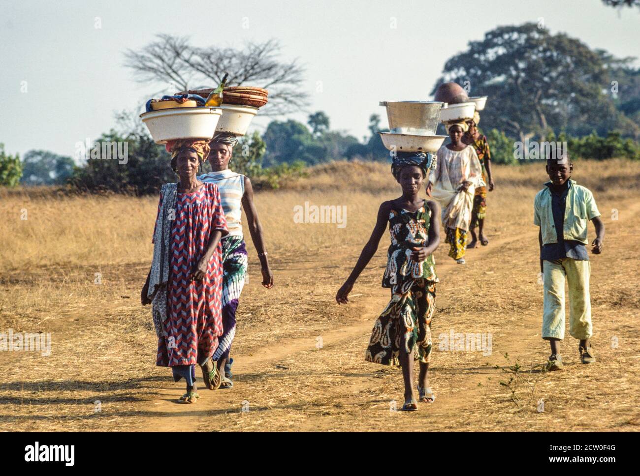 Village women walking back from market with their goods carried on ...