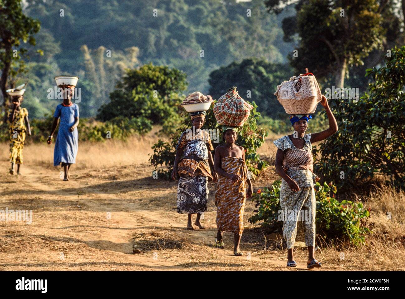 Village women walking back from market with their goods carried on ...