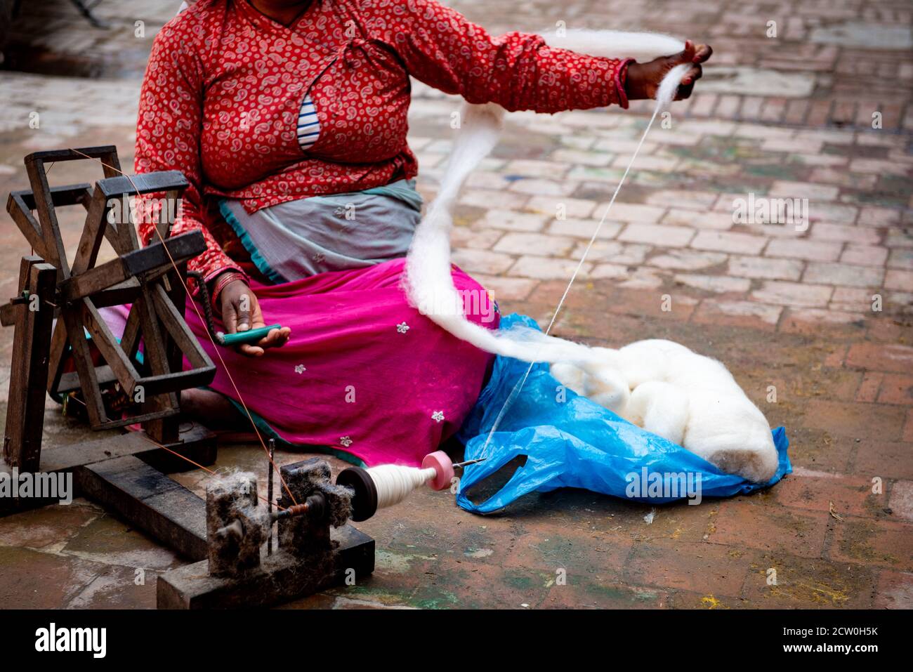 Nepalese woman spinning cotton thread on a wooden vintage machine ...