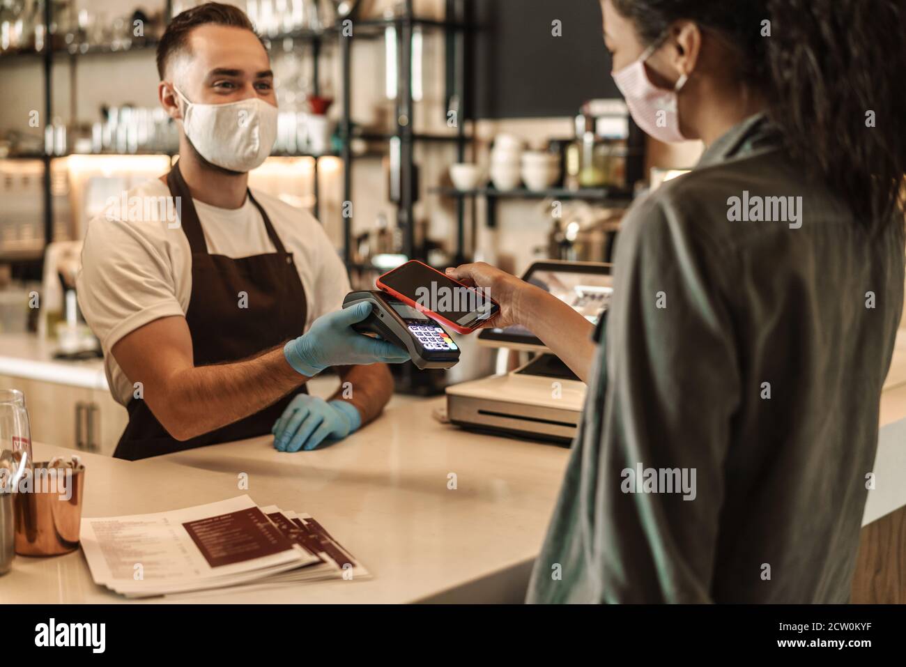 Customer paying and getting her order at the coffee shop counter during ...