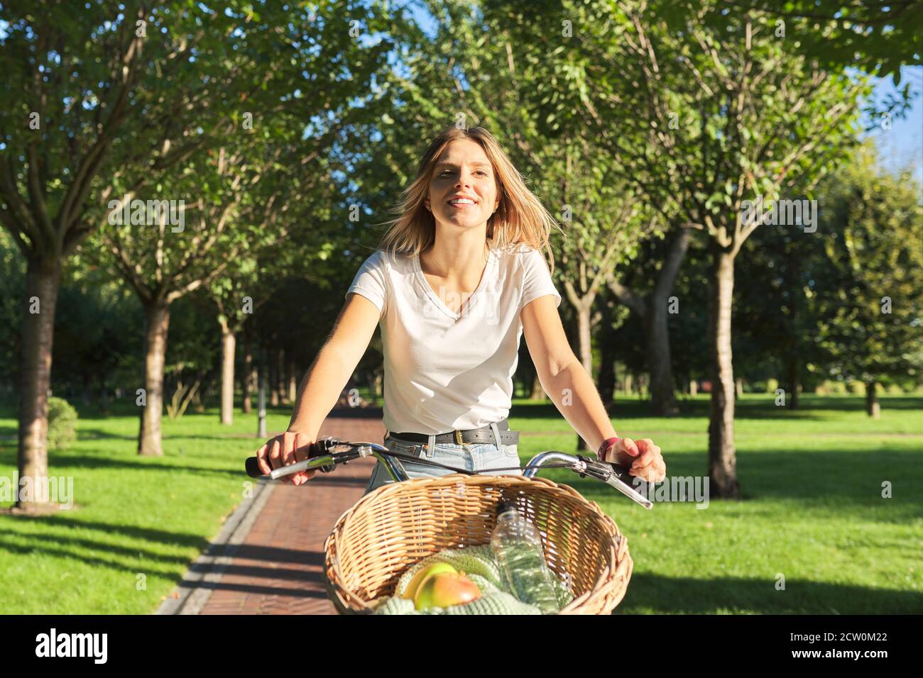 Young beautiful woman on vintage bike with basket rides on park Stock ...