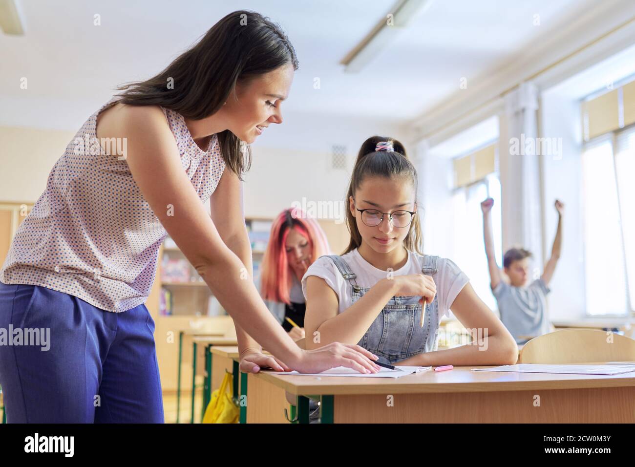 Young woman teacher teaches lesson in class of teenage children Stock ...