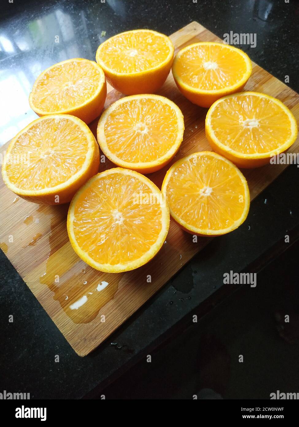 Orange being sliced and prepared for making healthy citric juice for a ...