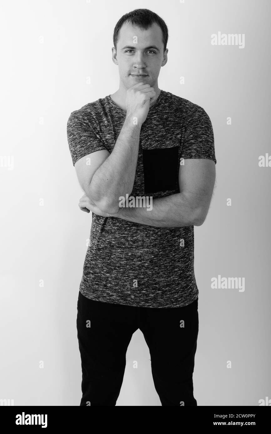 Studio shot of young muscular man standing while thinking against white ...