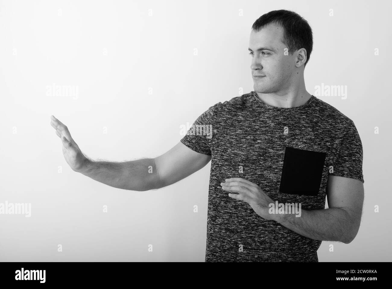 Profile view of young muscular man showing stop hand sign to the side ...