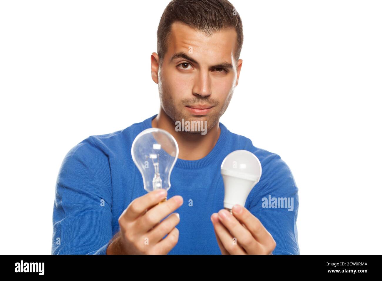 portrait of young man, holding LED bulb and old fachion bulb on white ...