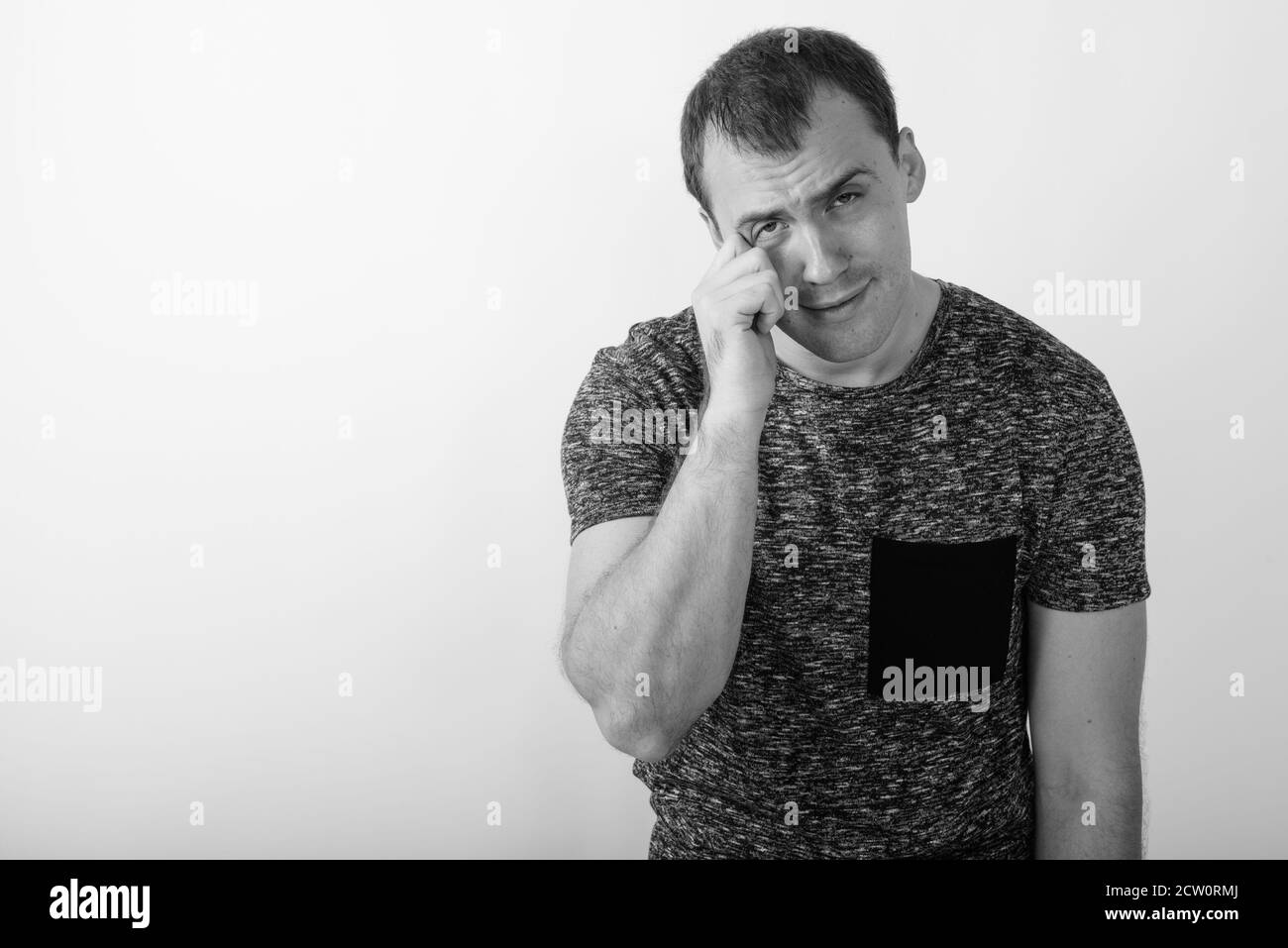Studio shot of stressed young muscular man looking sad while crying ...